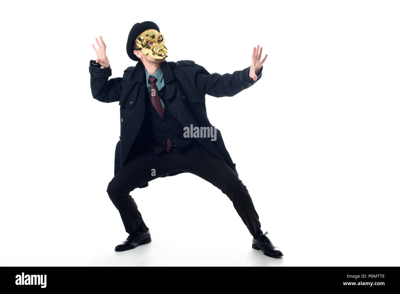 criminal in mask, hat and black coat posing isolated on white Stock ...