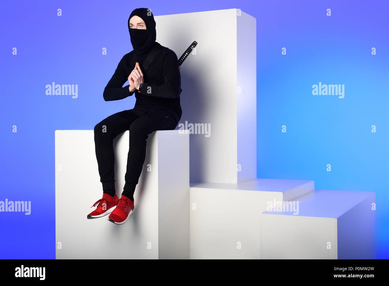ninja in black clothing with katana behind sitting on white block ...
