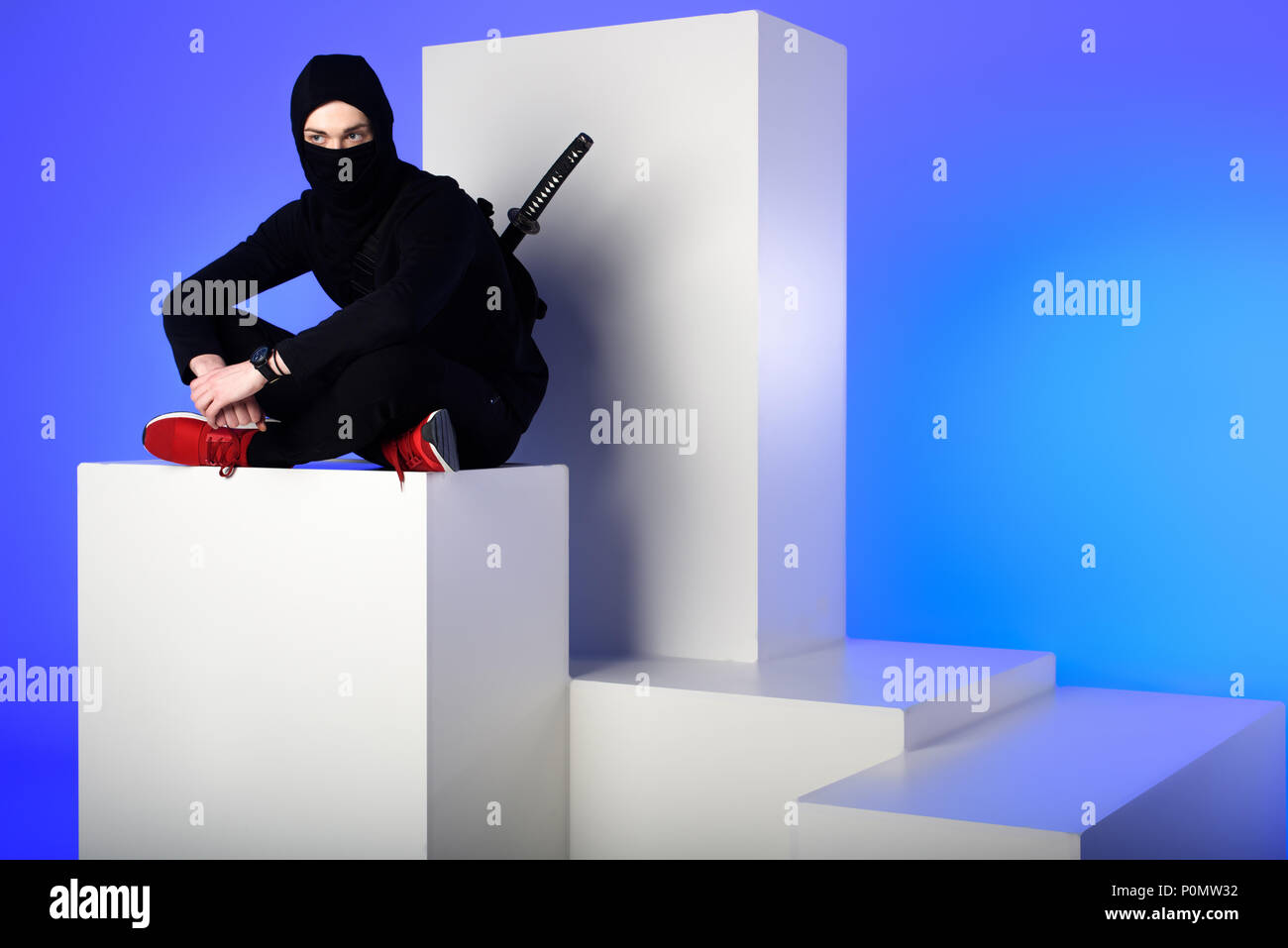 ninja in black clothing with katana behind sitting on white block ...
