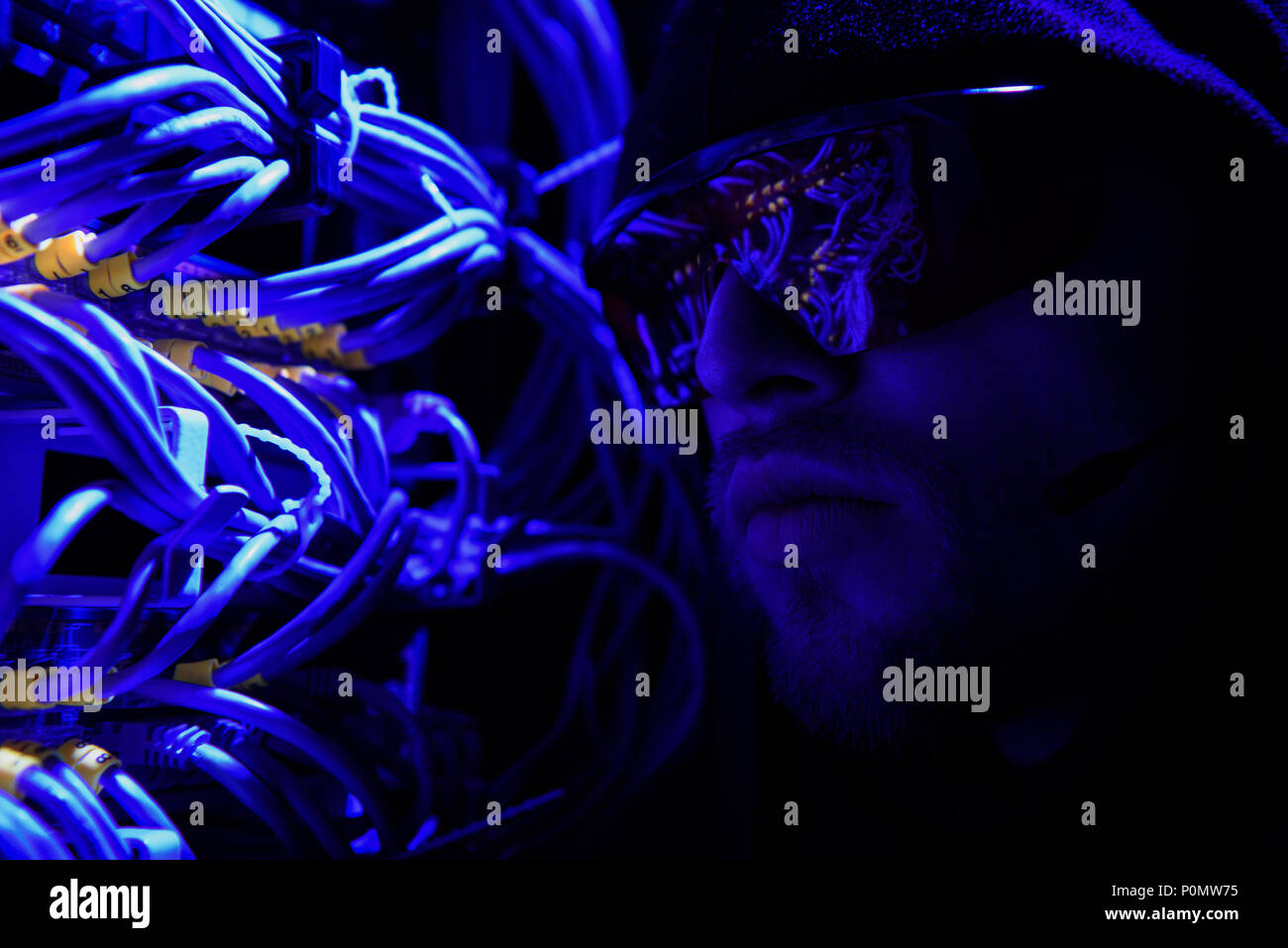 side view of hacker in eyeglasses looking at various wires Stock Photo ...