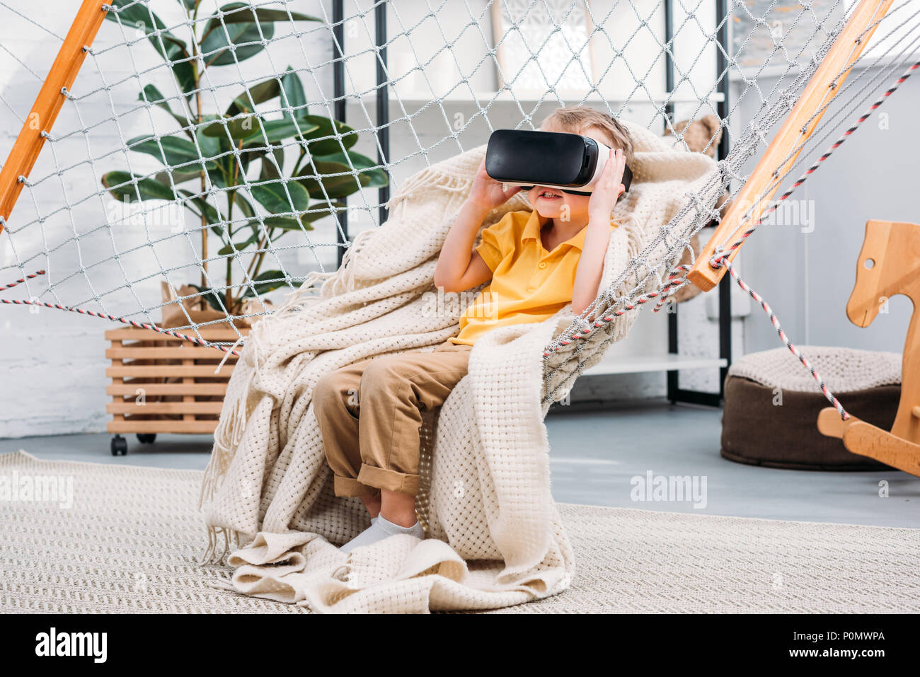 Boy in rope hammock using virtual reality headset Stock Photo - Alamy