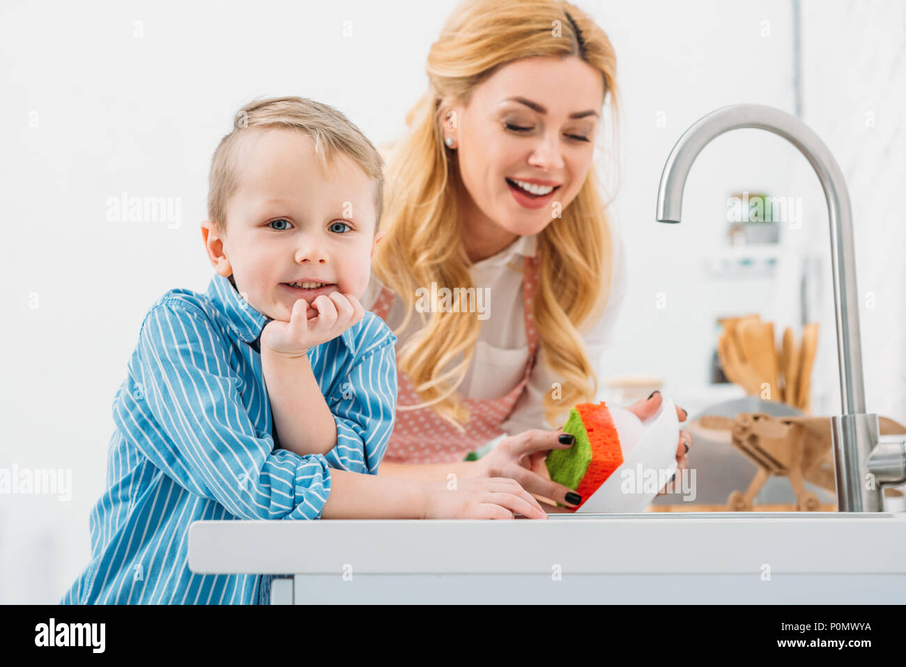 Little boy and mother washing up plate by sponge Stock Photo - Alamy