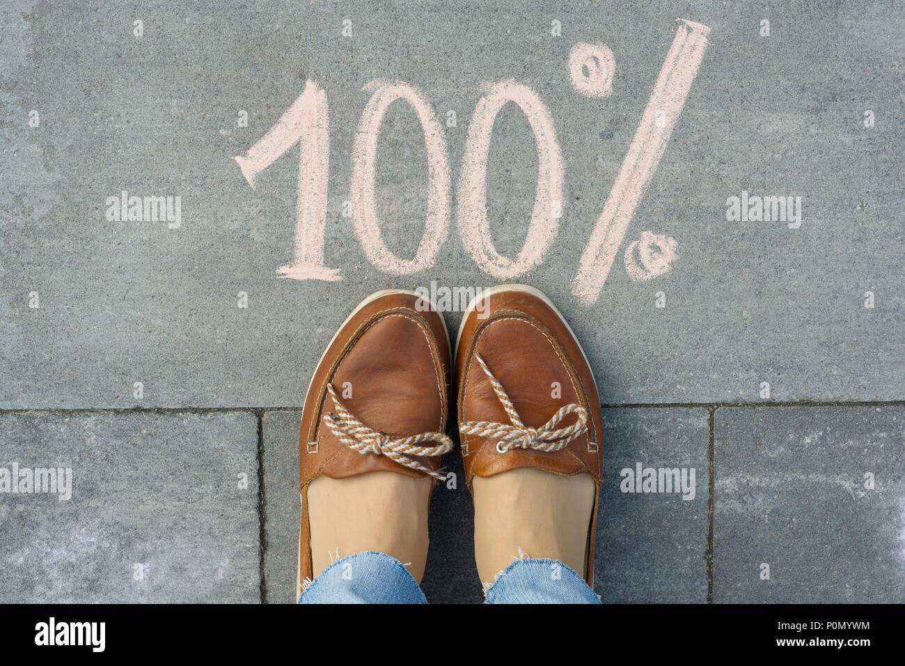 Female feet with text 100 percent written on grey sidewalk Stock Photo ...