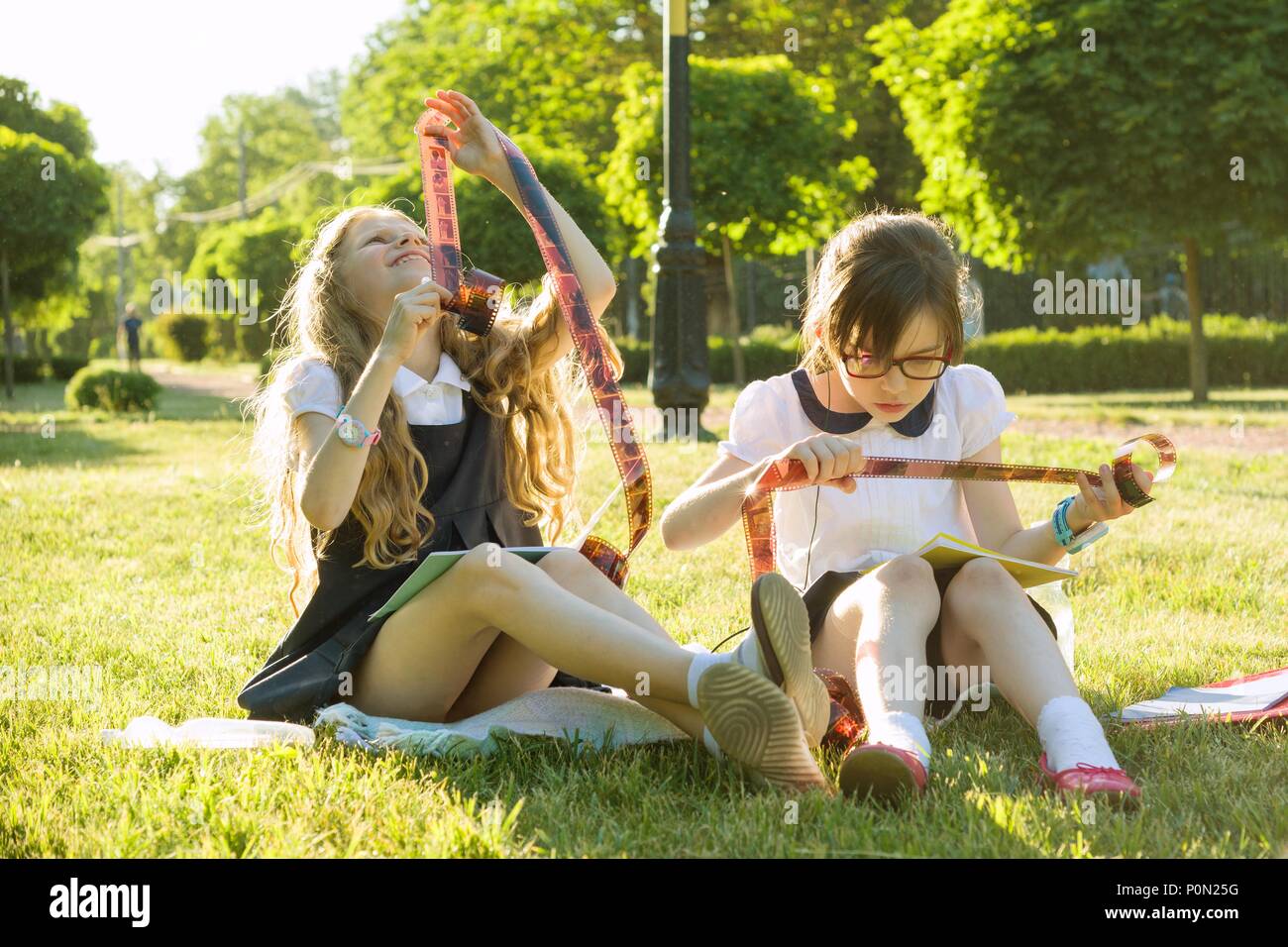 Two little girls with interest and surprise view film photo negatives ...