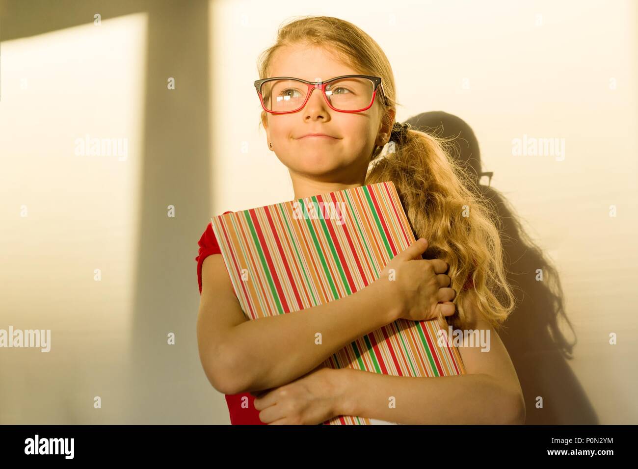 Girl child elementary school student wearing glasses is holding a ...
