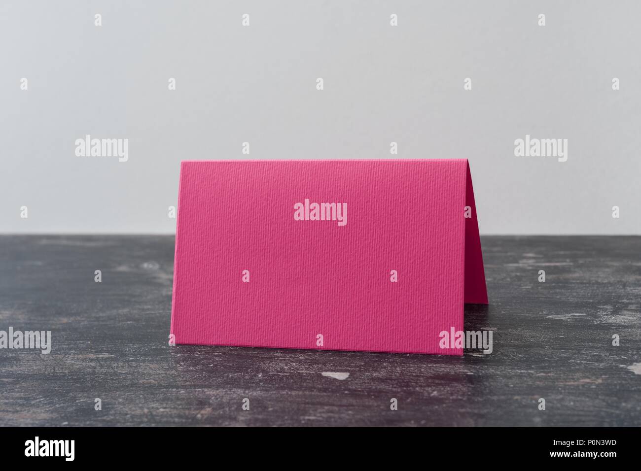 Pink blank card on dark table. Light background Stock Photo - Alamy