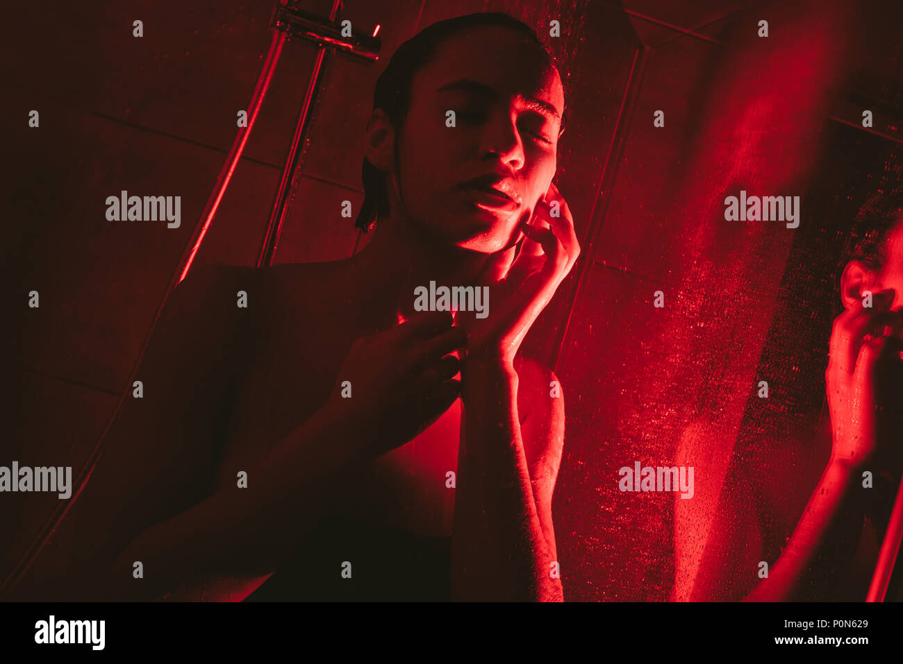 Attractive African American Woman Taking Shower In Red Light Stock