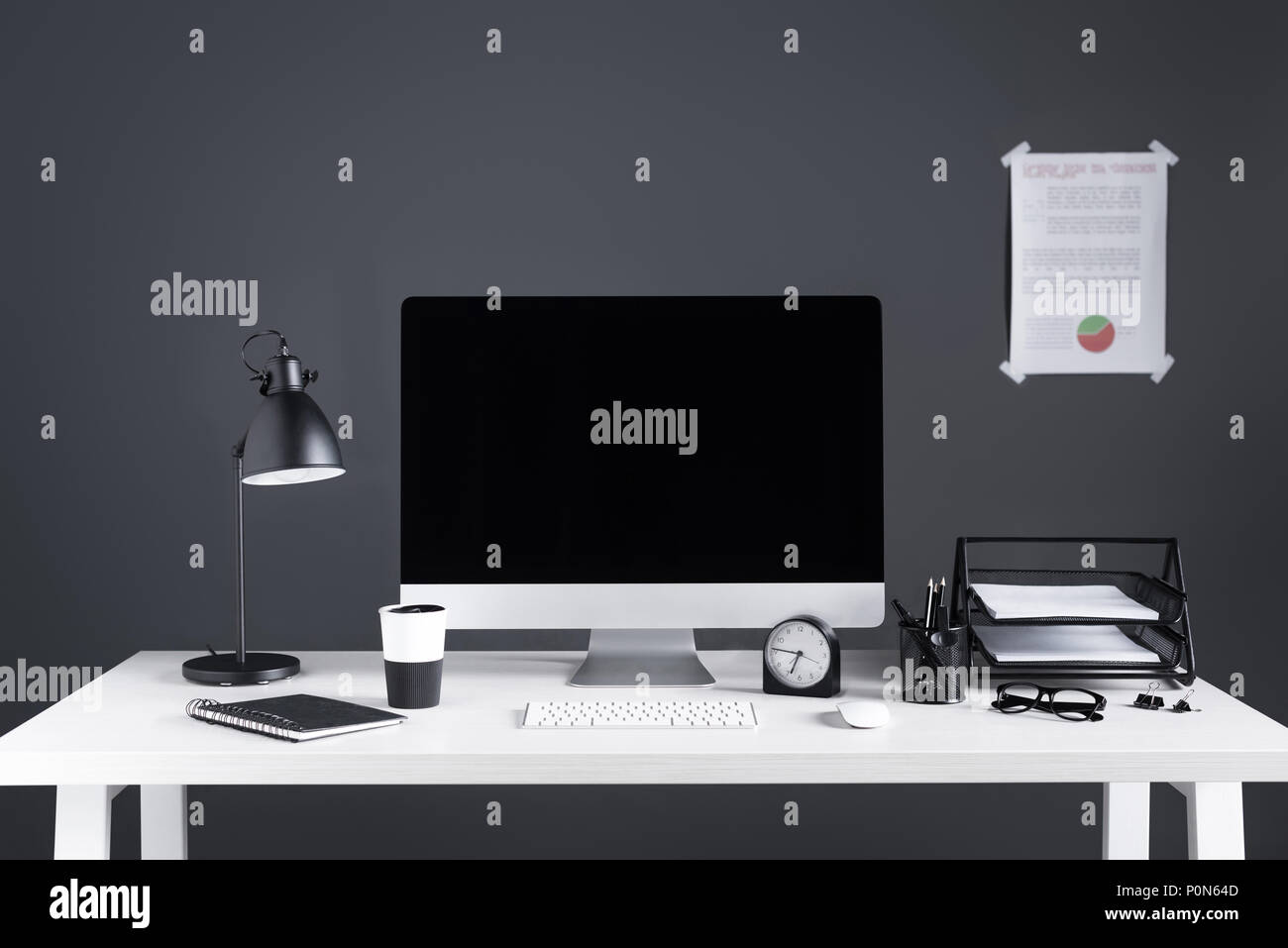 desktop computer with blank screen, business chart, clock and office ...