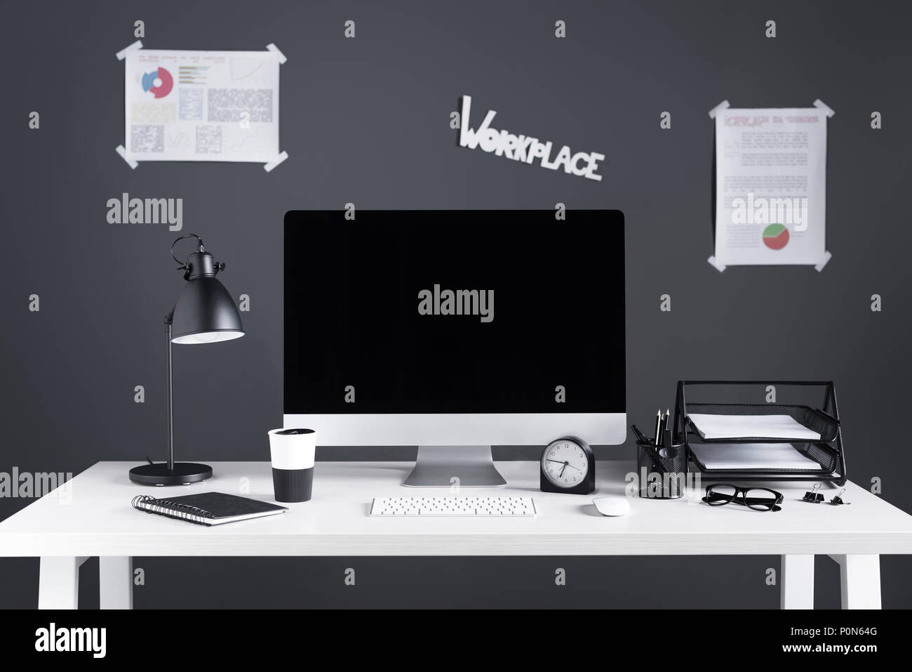 desktop computer with blank screen, business charts and office supplies ...