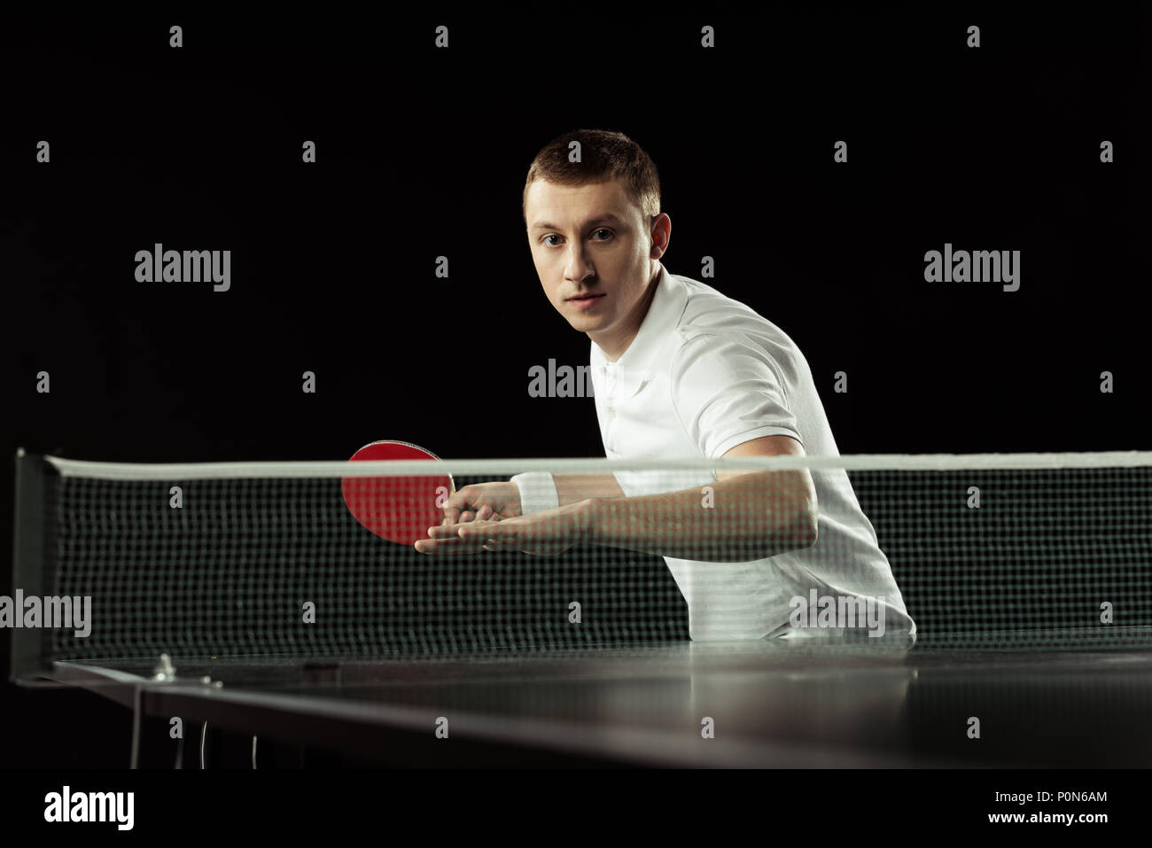 young focused tennis player in uniform practicing in table tennis ...