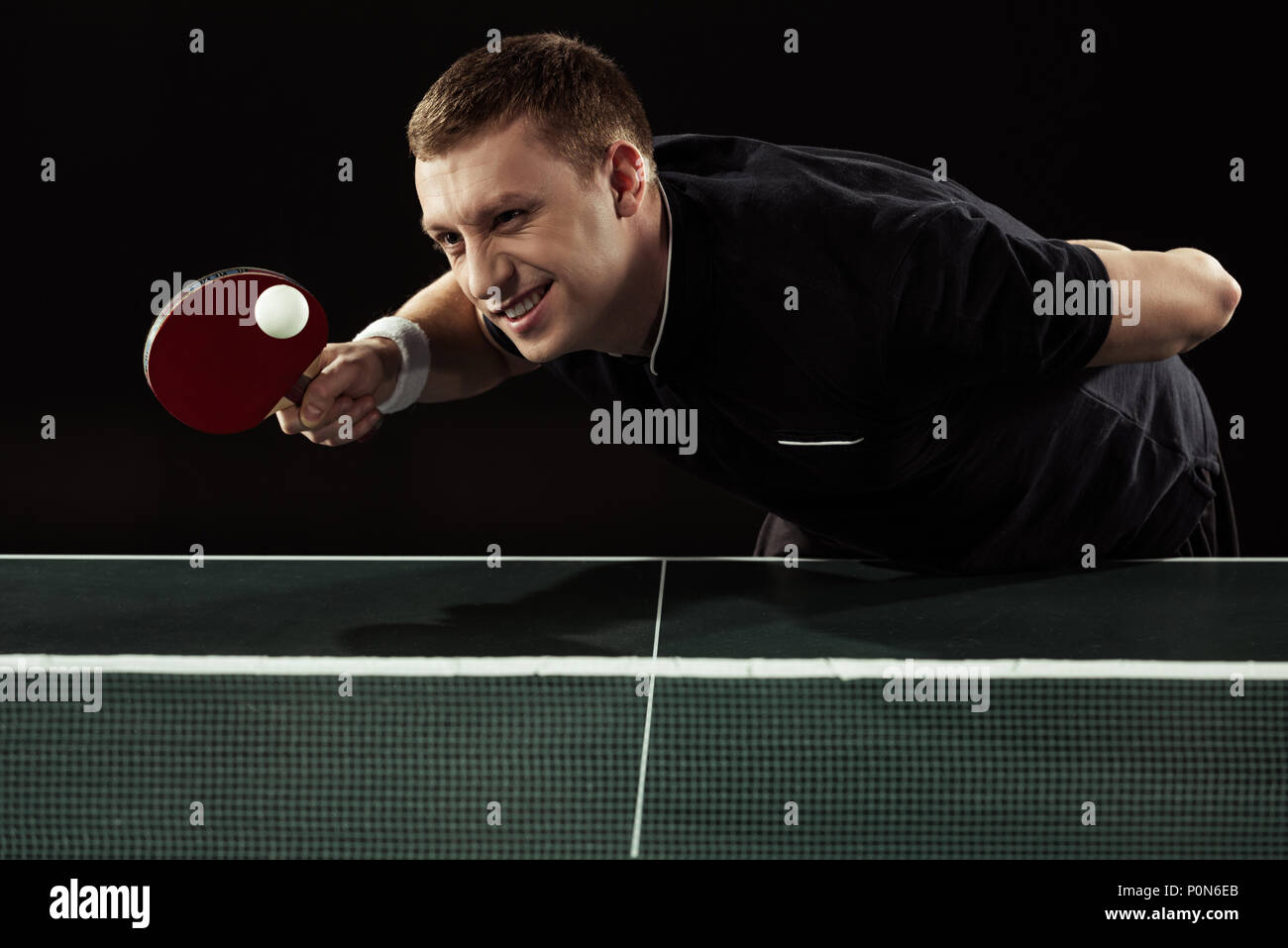 portrait of emotional tennis player playing table tennis isolated on ...