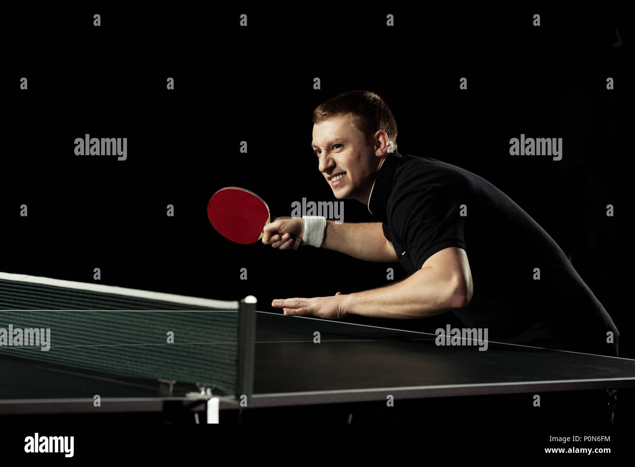 side view of emotional tennis player practicing in table tennis ...