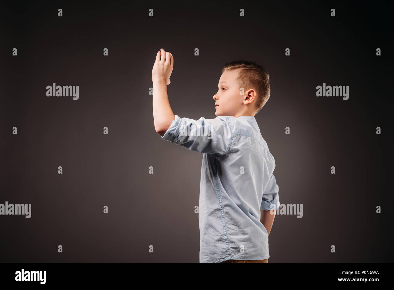 preteen boy holding something, isolated on grey Stock Photo - Alamy