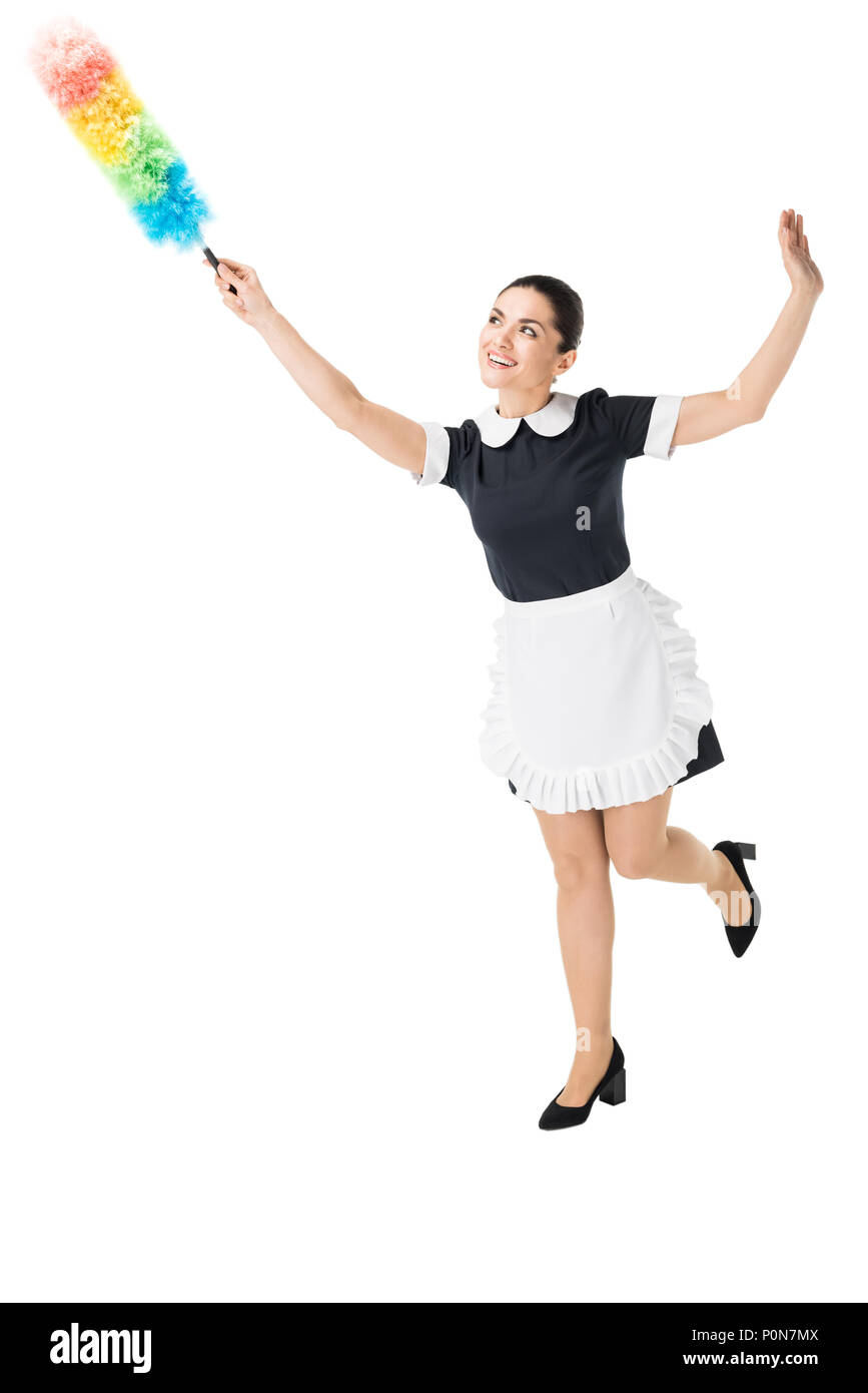 Young maid in professional uniform using colorful duster isolated on ...