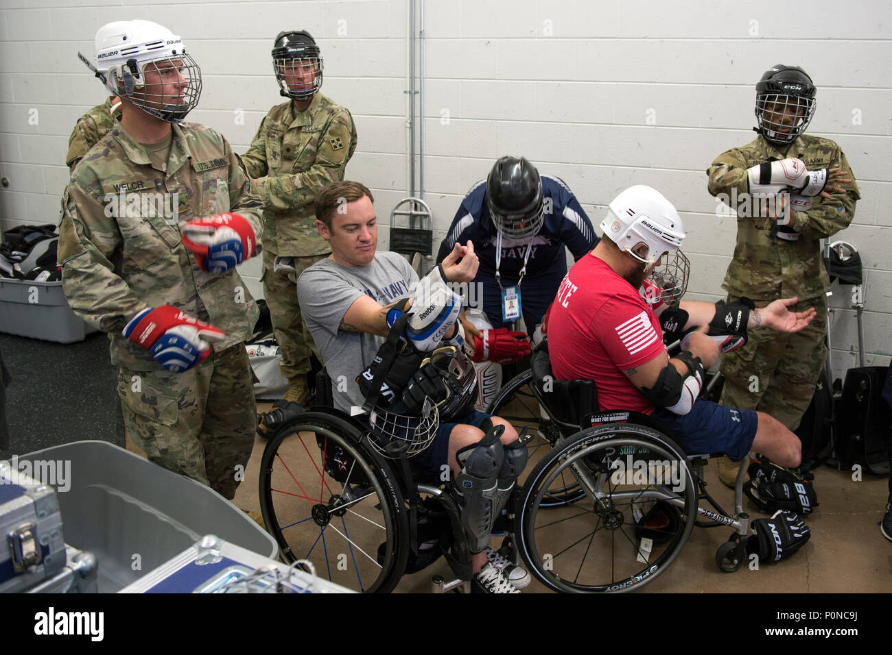 Soldiers and members of Team Navy dress for an exhibition sled hockey ...