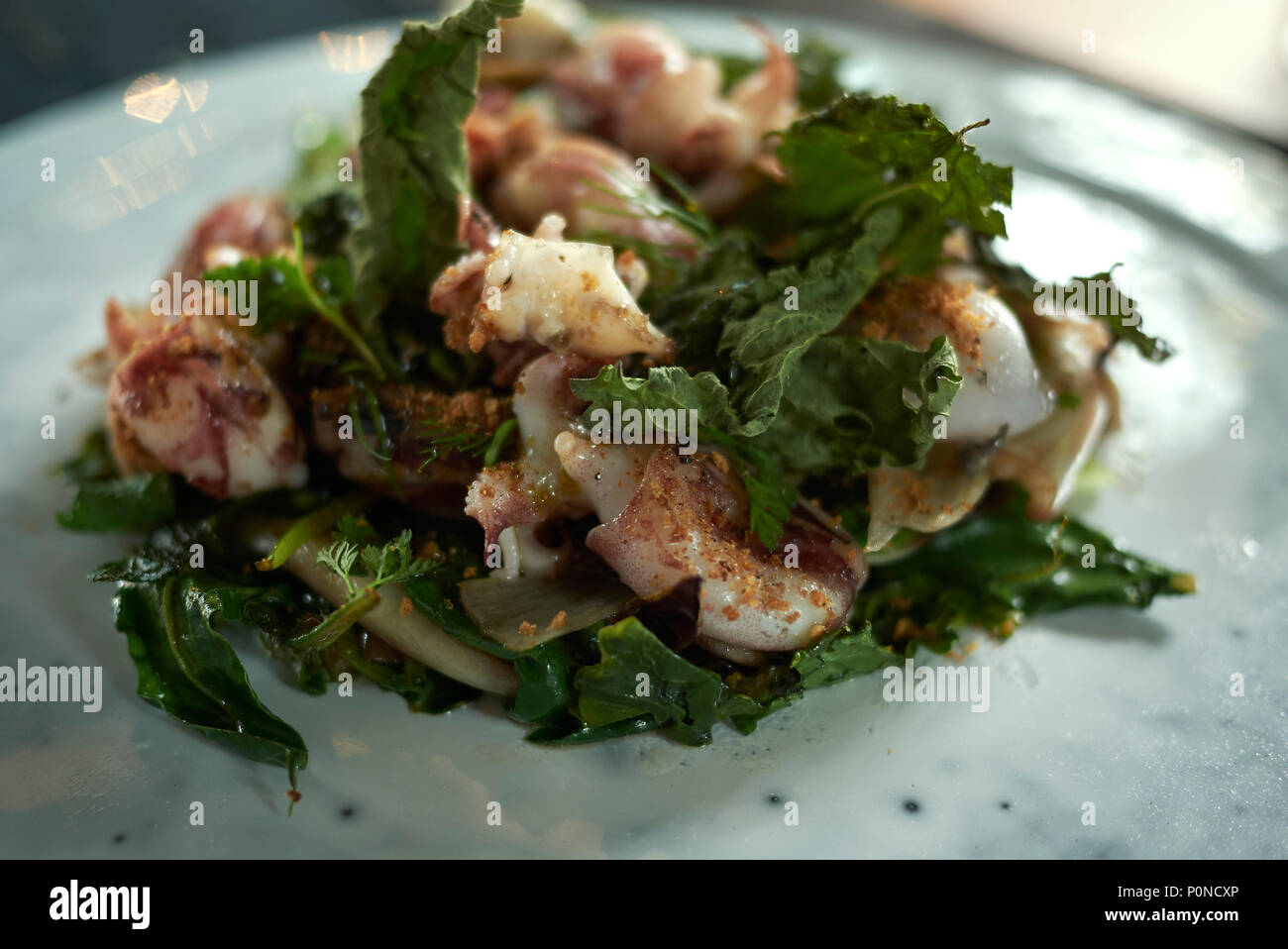 Baby calamari with wild greens Stock Photo - Alamy