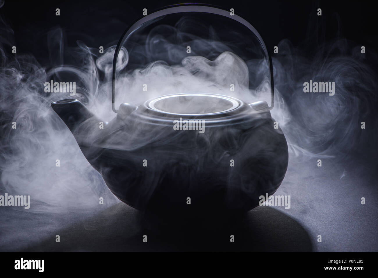 close-up view of black kettle with hot steam on black Stock Photo - Alamy