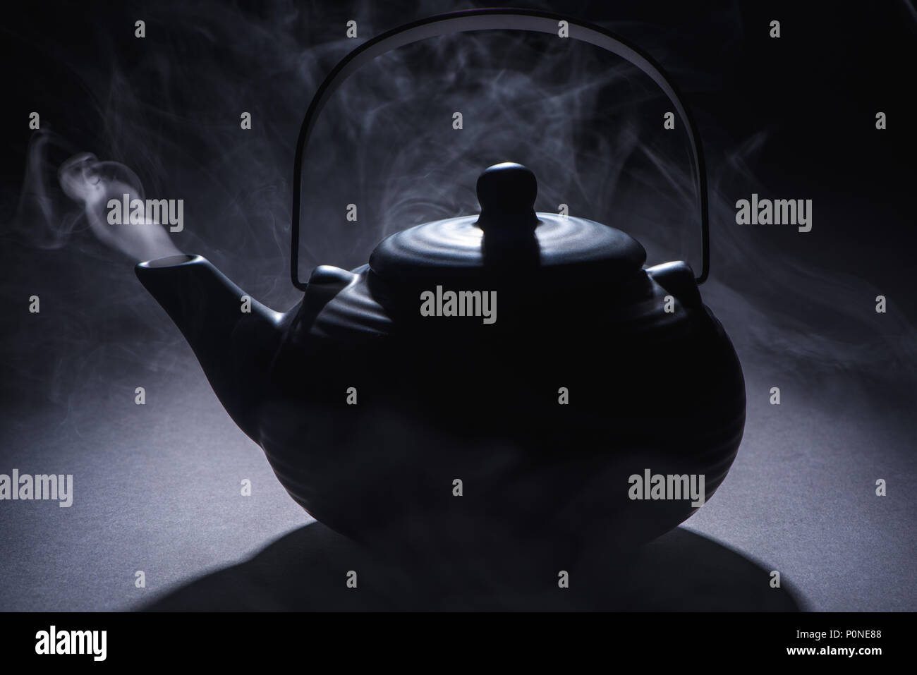 close-up view of black chinese teapot with hot steam on black Stock ...