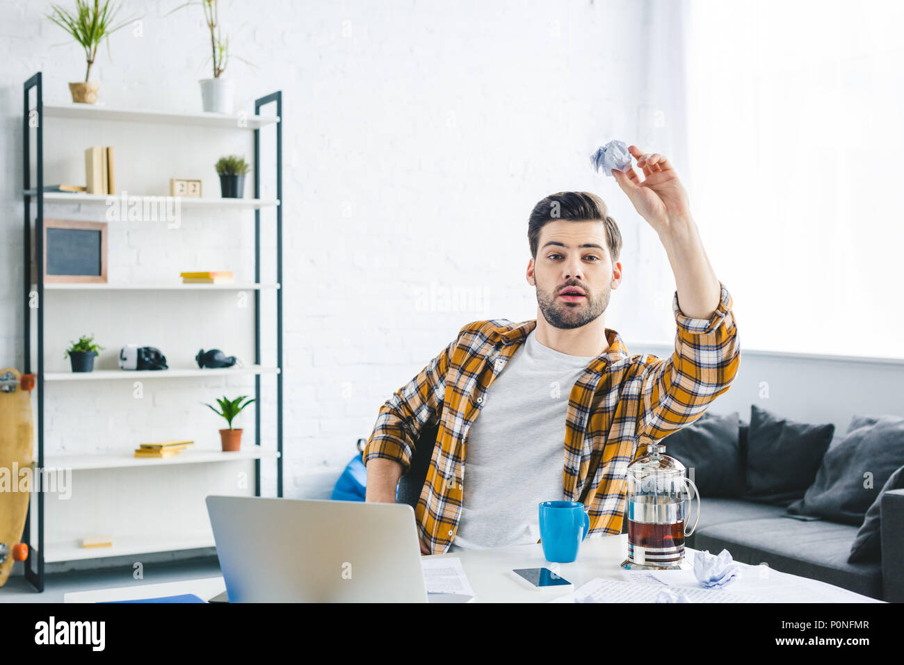 Man throwing crumpled paper while working at home office Stock Photo ...