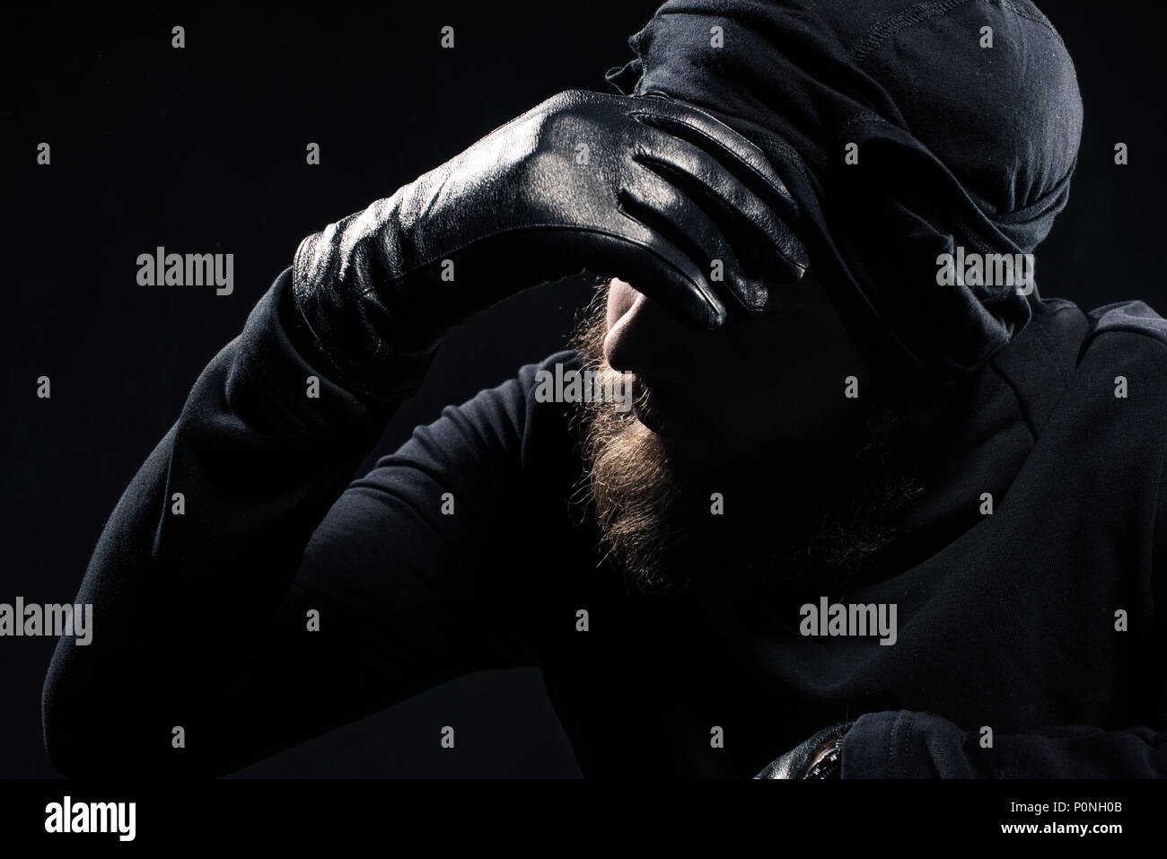 Robber in balaclava leaning his head on hand Stock Photo - Alamy