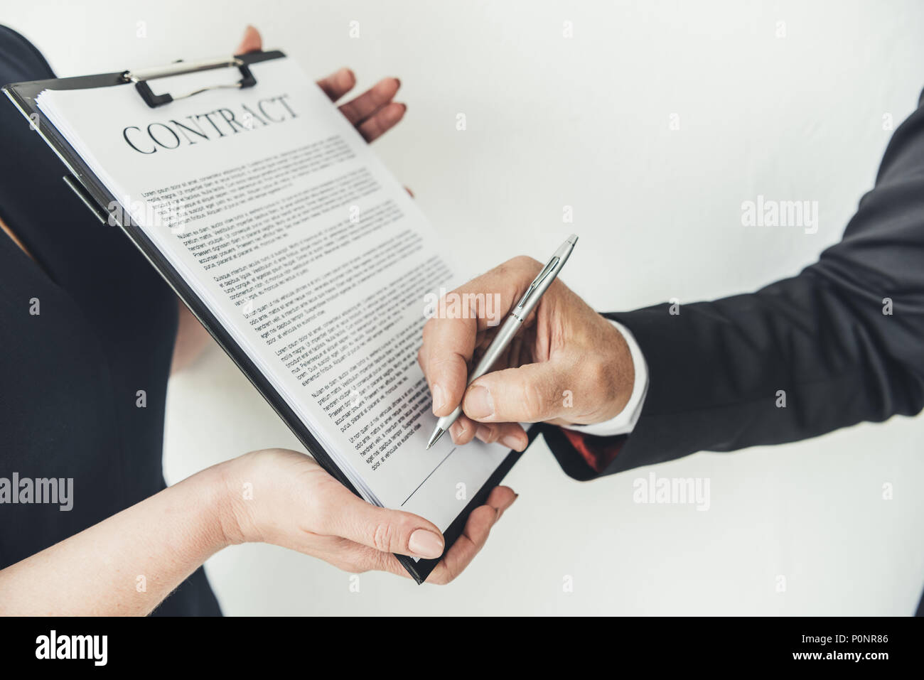 close-up view of business partners sign blank contract page Stock Photo ...