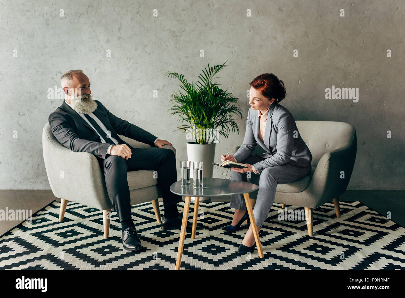stylish mature business partners conversing in loft office Stock Photo ...