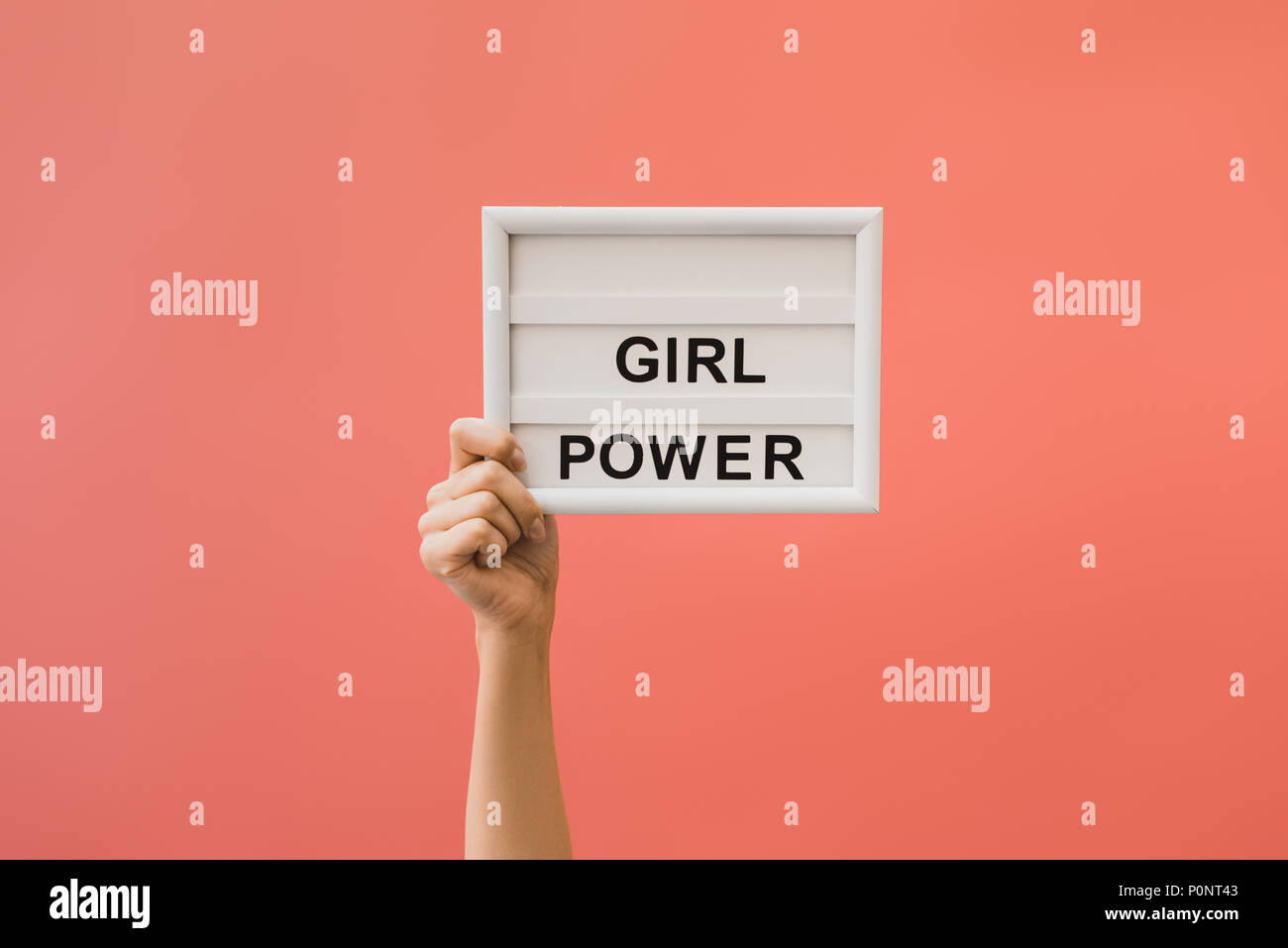 partial view of female hand holding board with girl power lettering ...