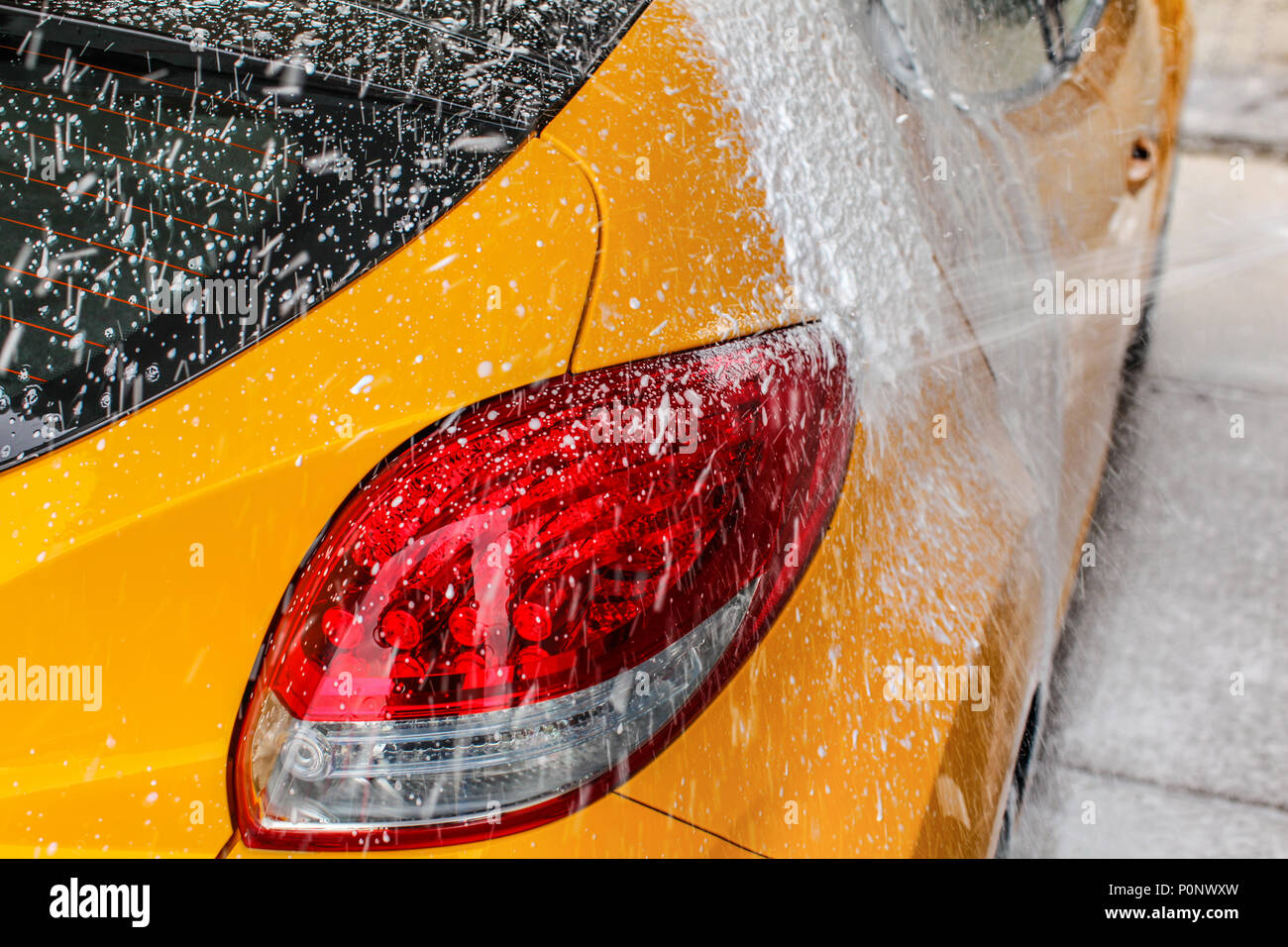 Soap foam splatter on yellow car washed in carwash Stock Photo - Alamy
