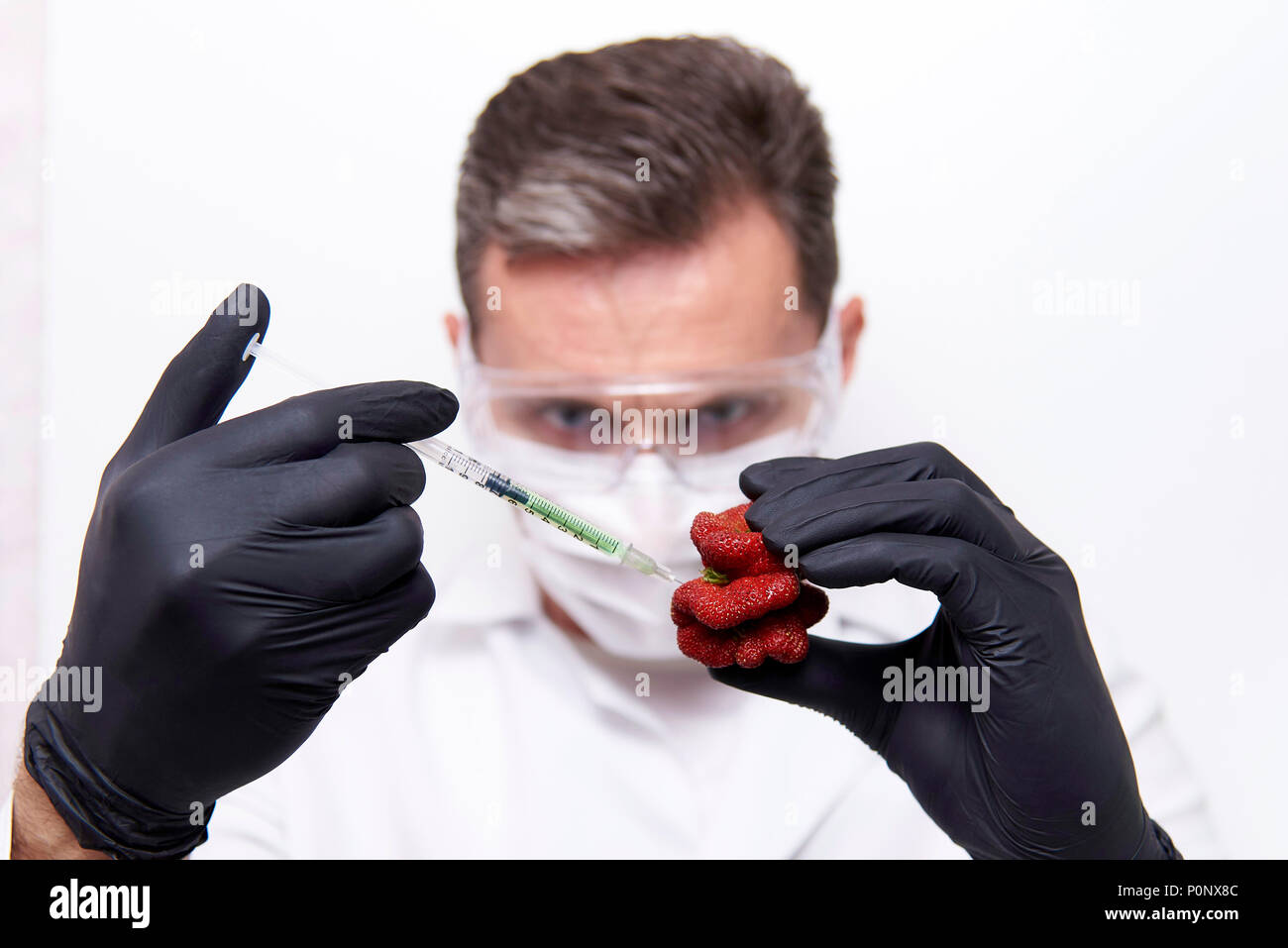 Hands of a scientist in black gloves with a syringe with an injection ...