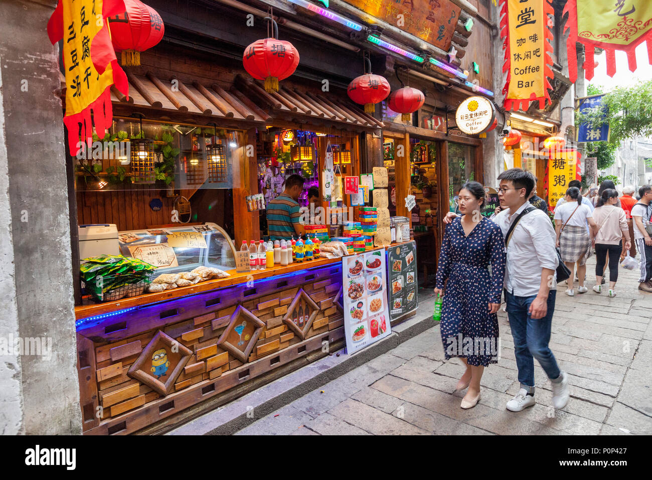 Suzhou, Jiangsu, China. Chinese Couple Passing a Coffee Bar on Shantang ...