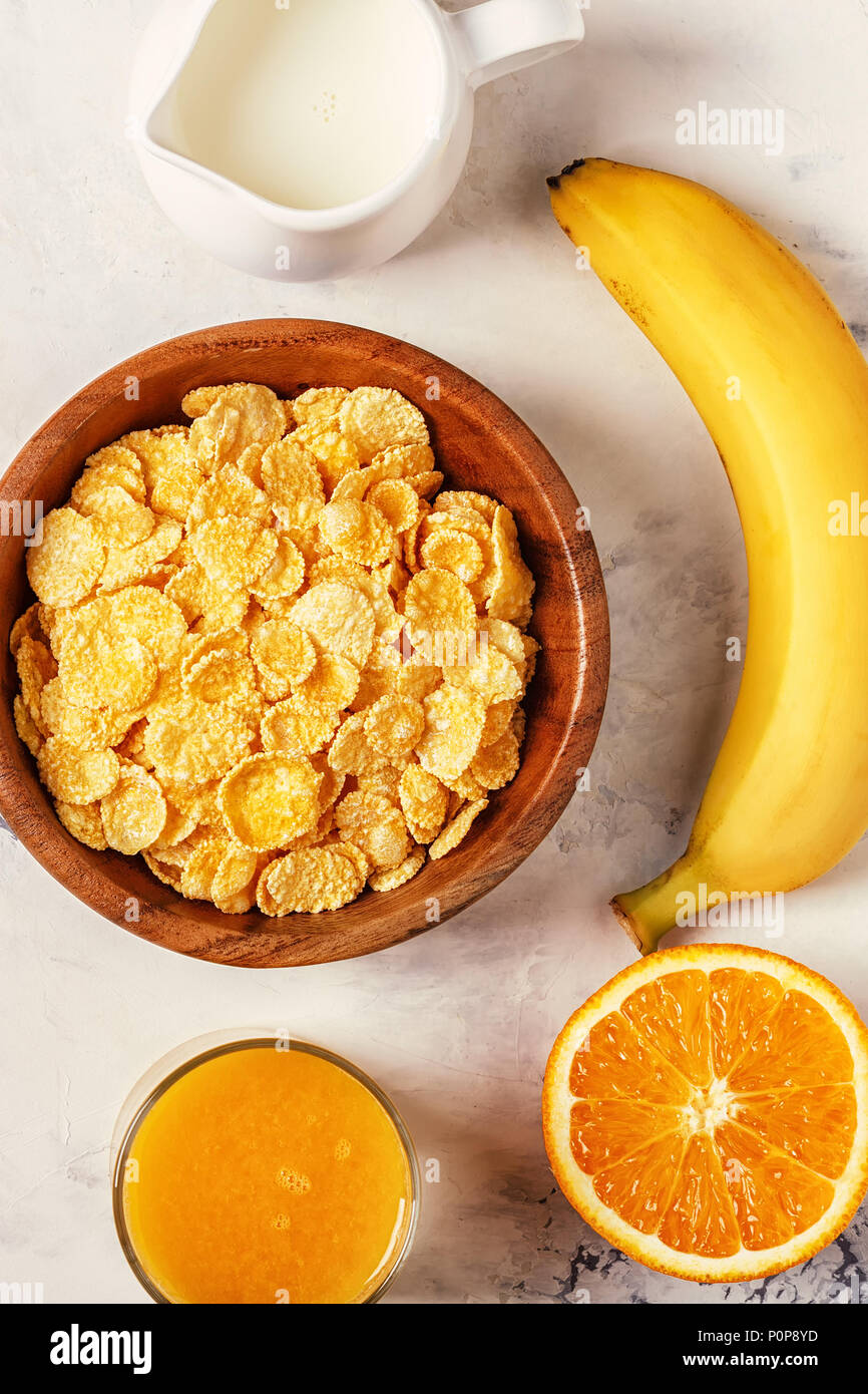 Healthy breakfast - bowl of corn flakes, fruit, nuts, orange juice ...
