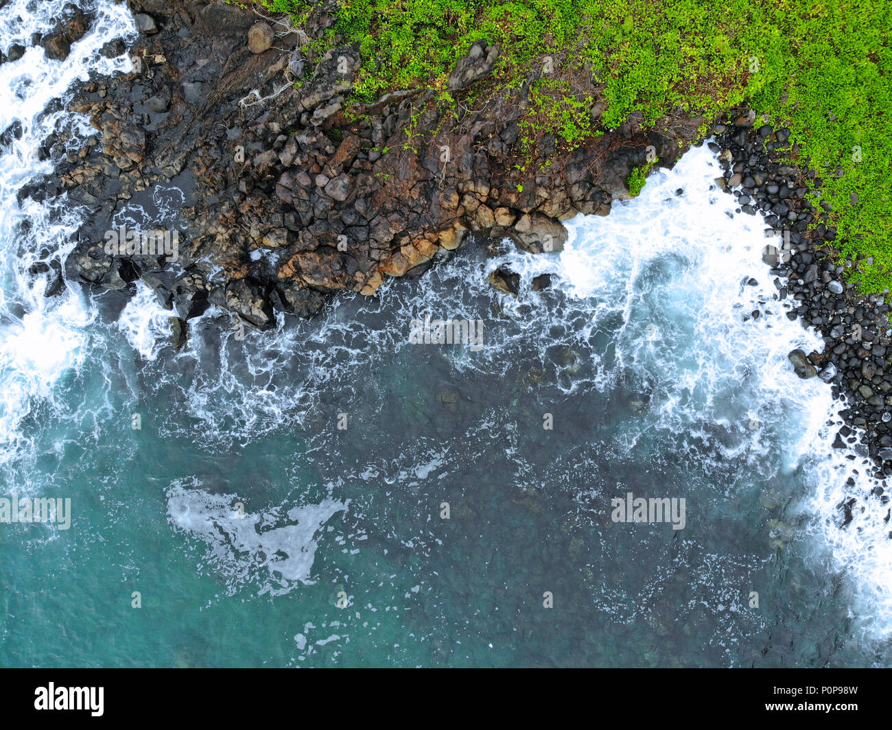 Aerial view of a black volcanic rock beach and ocean in Wailea, Maui ...
