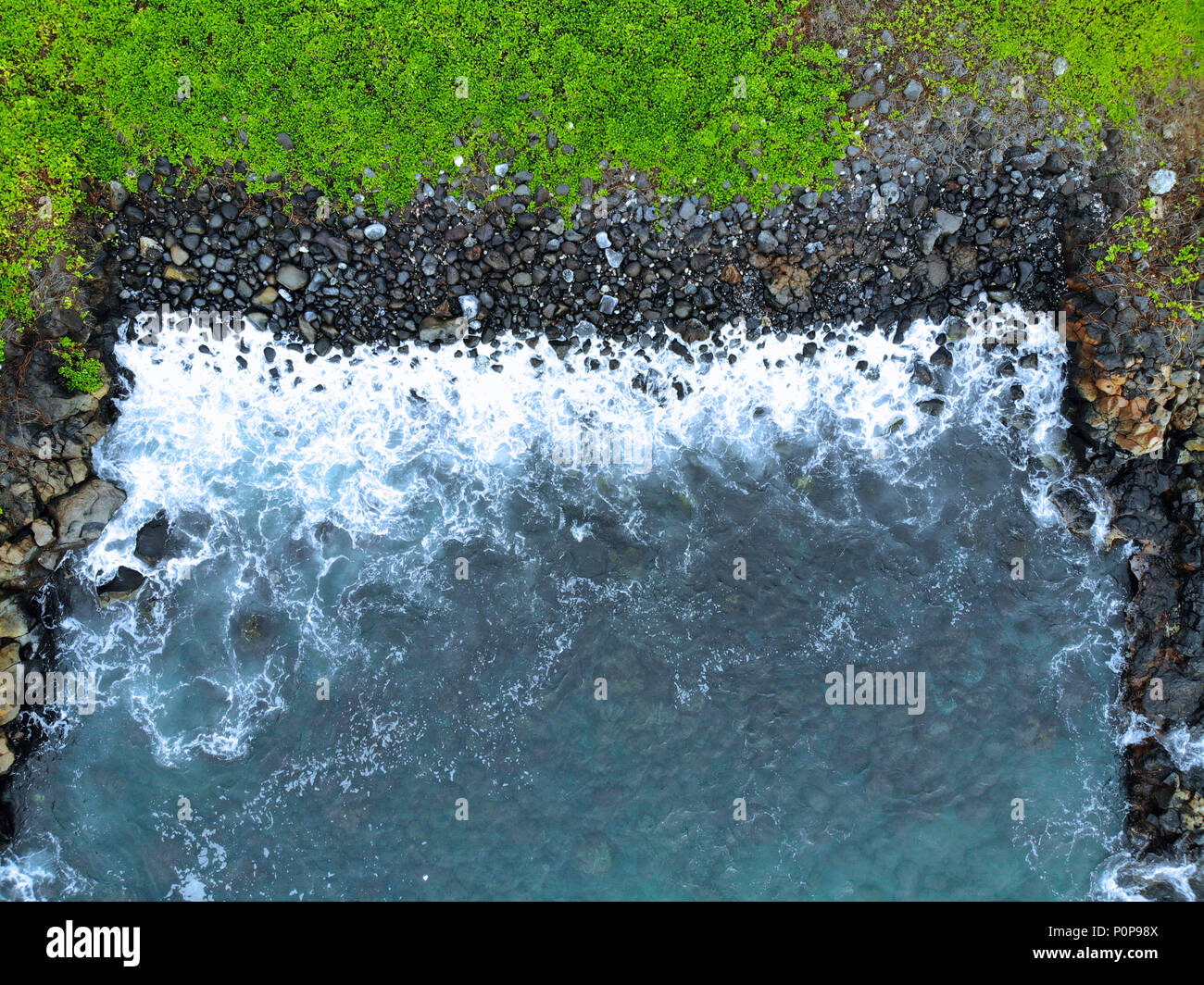 Aerial view of a black volcanic rock beach and ocean in Wailea, Maui ...