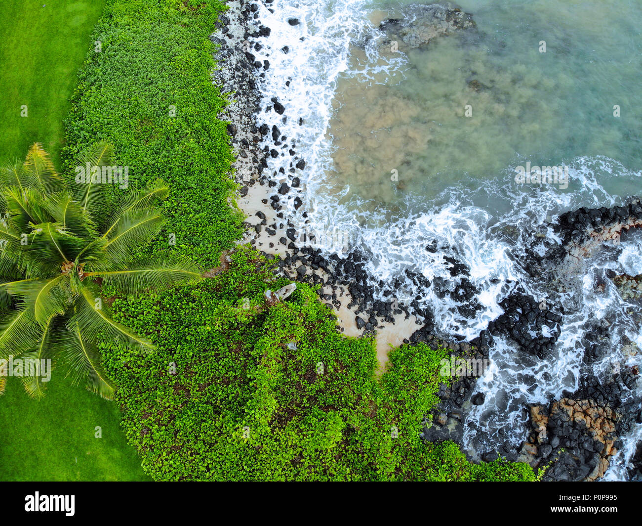 Aerial view of a black volcanic rock beach and ocean in Wailea, Maui ...
