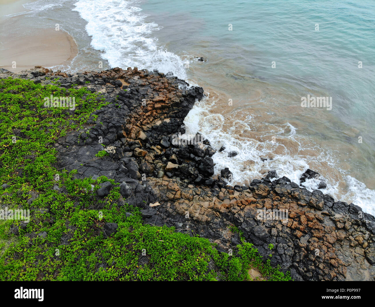 Aerial view of a black volcanic rock beach and ocean in Wailea, Maui ...