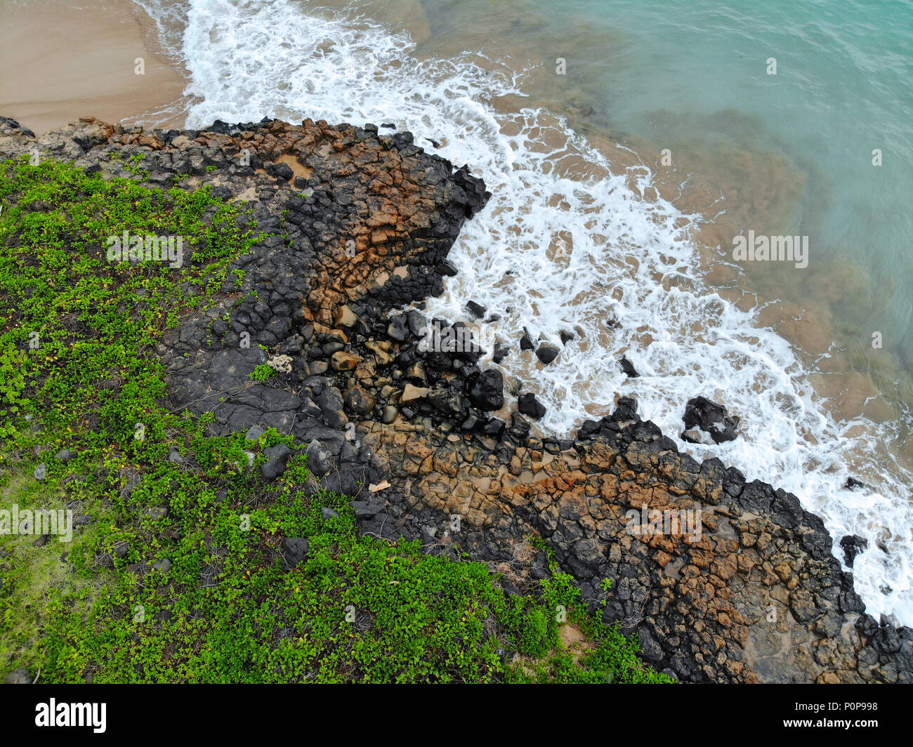Aerial view of a black volcanic rock beach and ocean in Wailea, Maui ...