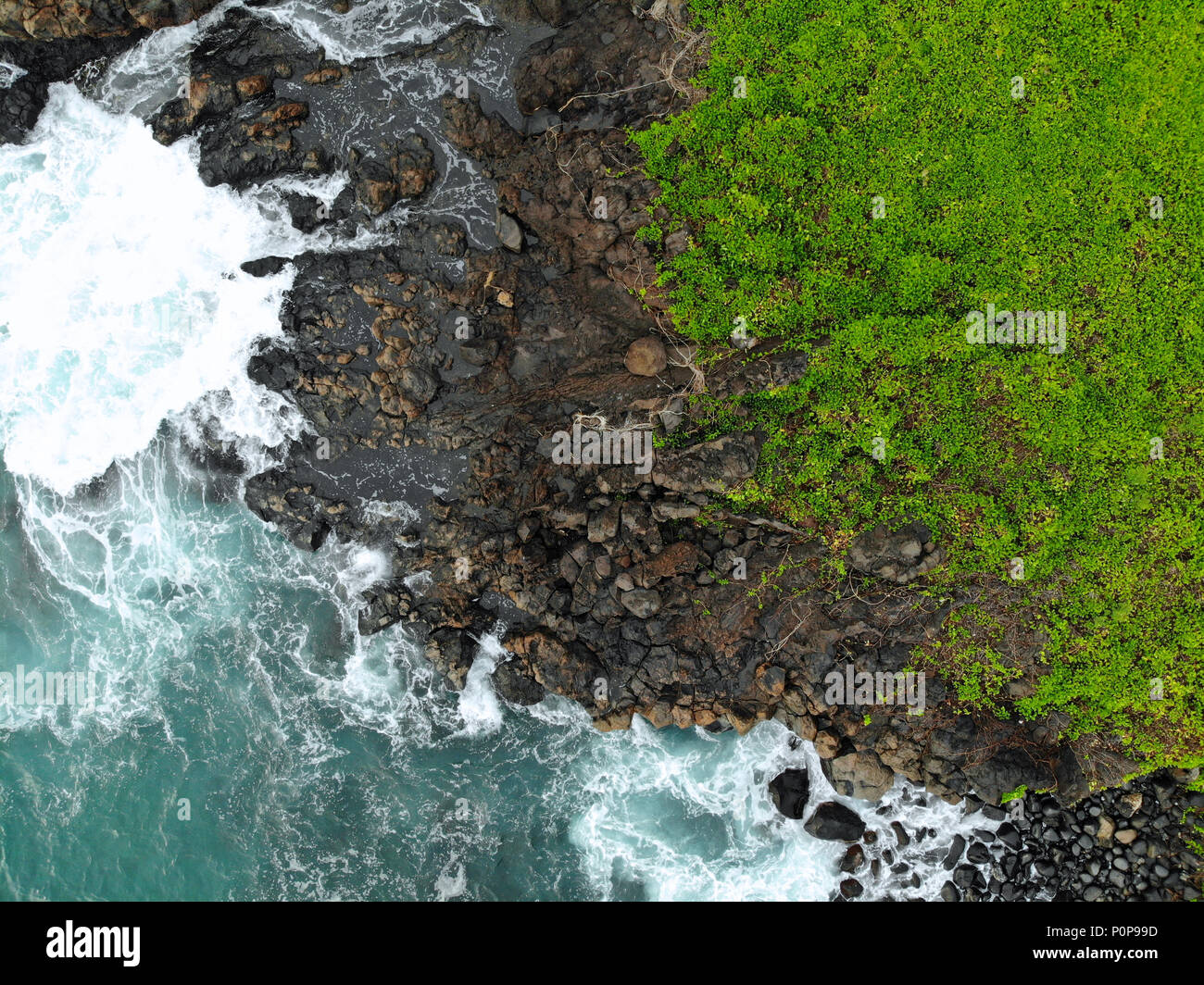 Aerial view of a black volcanic rock beach and ocean in Wailea, Maui ...