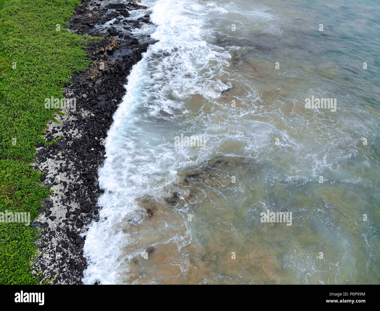Aerial view of a black volcanic rock beach and ocean in Wailea, Maui ...