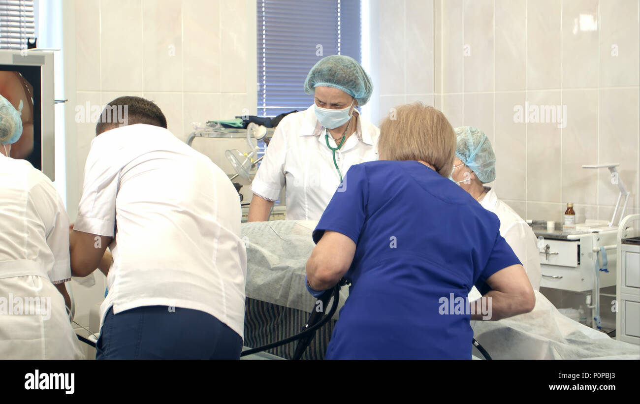 Group of doctors and nurses looking at the monitor during surgical ...