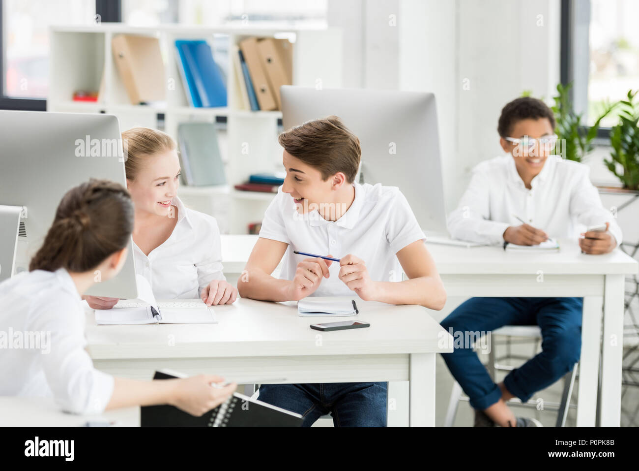 multicultural students having conversation together during class in ...