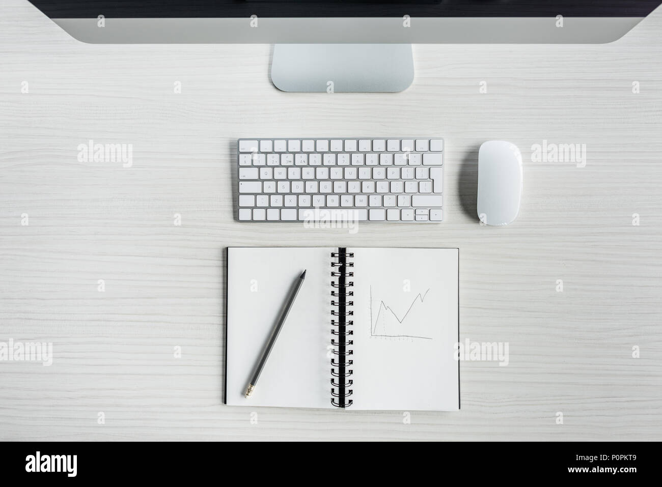 top view of computer screen, mouse, keyboard and notebook with drawn ...