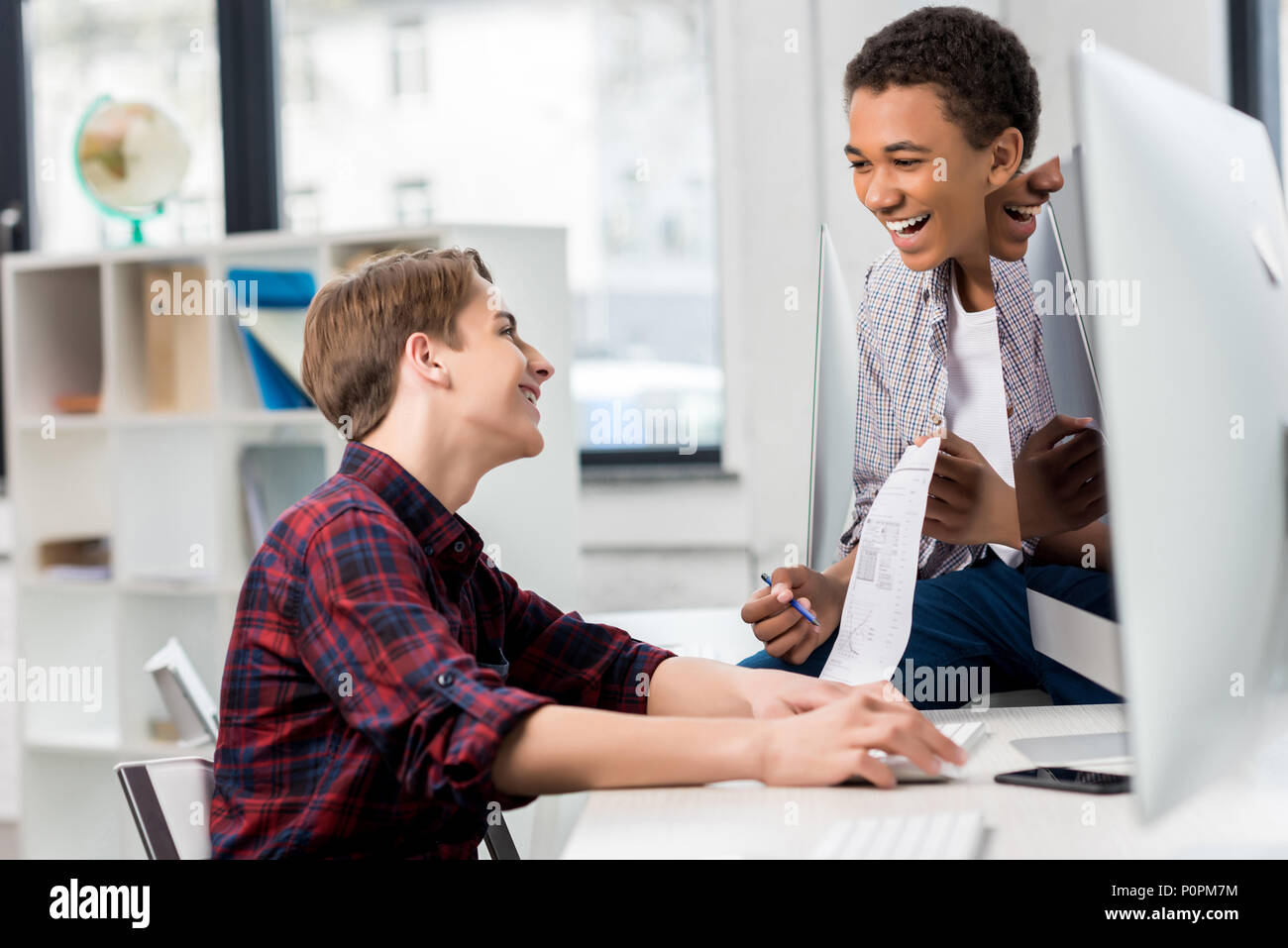 side view of multicultural teen boys studying together in class Stock ...