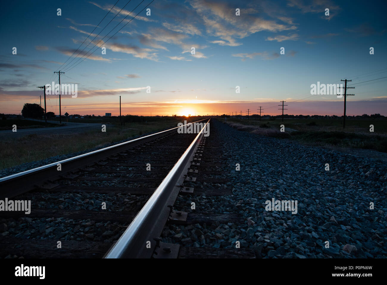 Local train tracks at sunset Stock Photo - Alamy