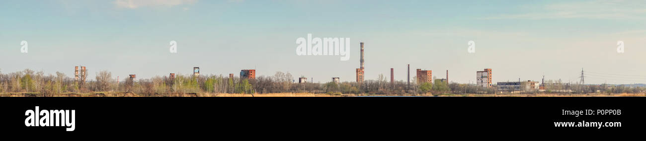 Old Abandoned chemical factory with chimneys on the banks of the river ...