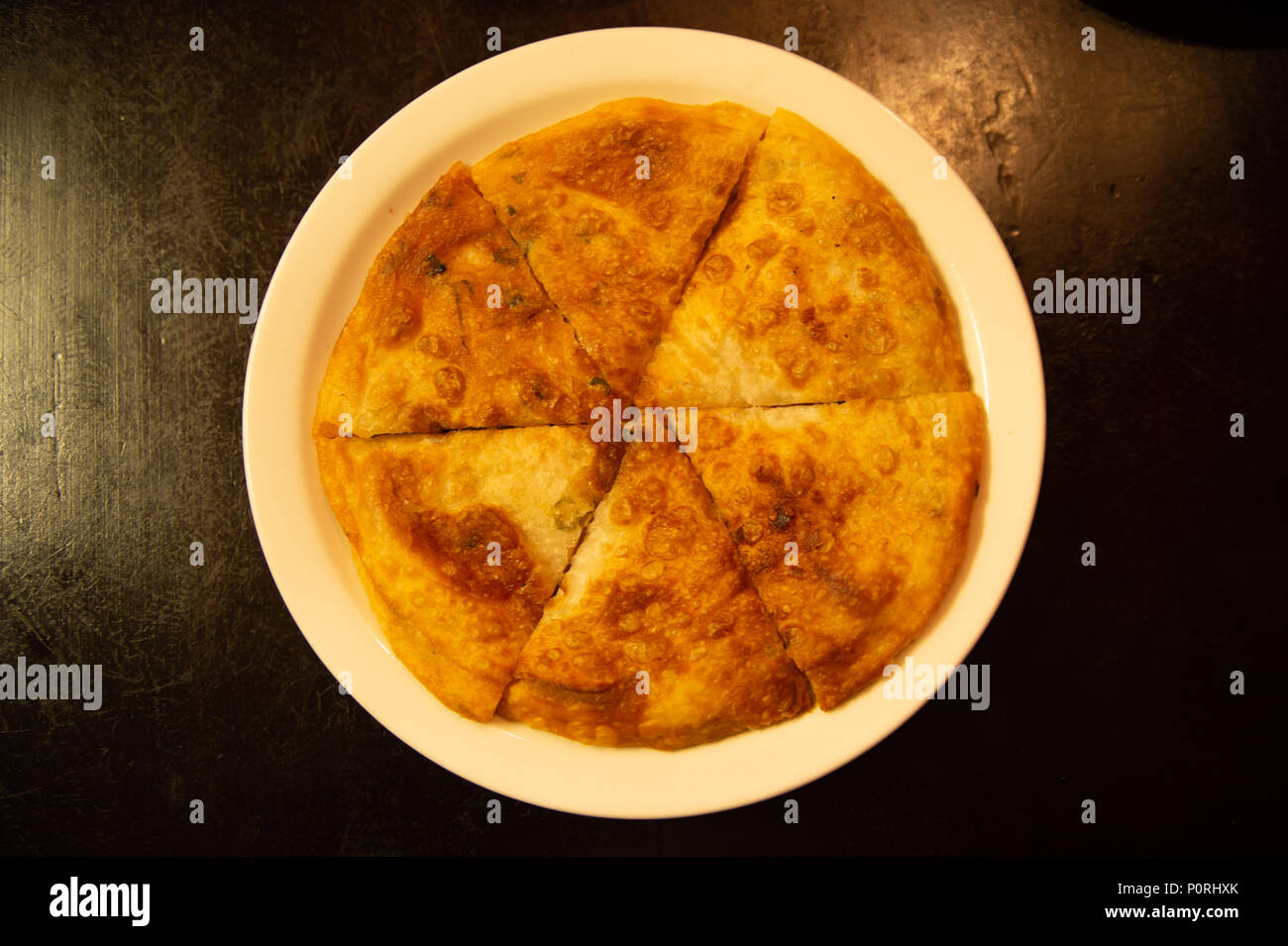 Uyghur cuisine: Handmade onion bread freshly made and cut into pieces ...