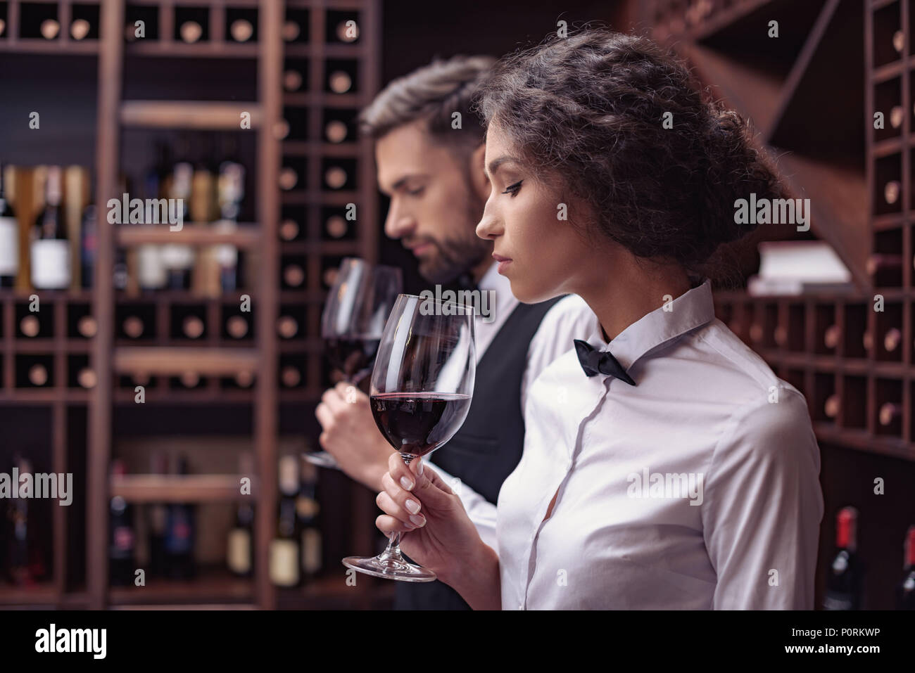 Two sommeliers, male and female tasting red wine in cellar Stock Photo ...