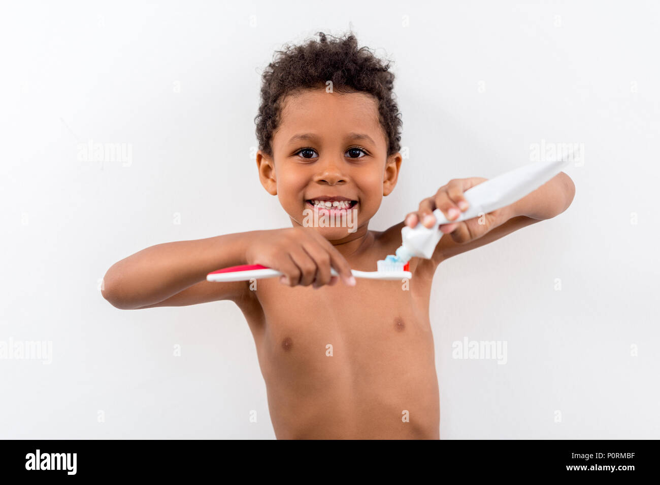 adorable african-american kid applying tooth paste on brush Stock Photo ...