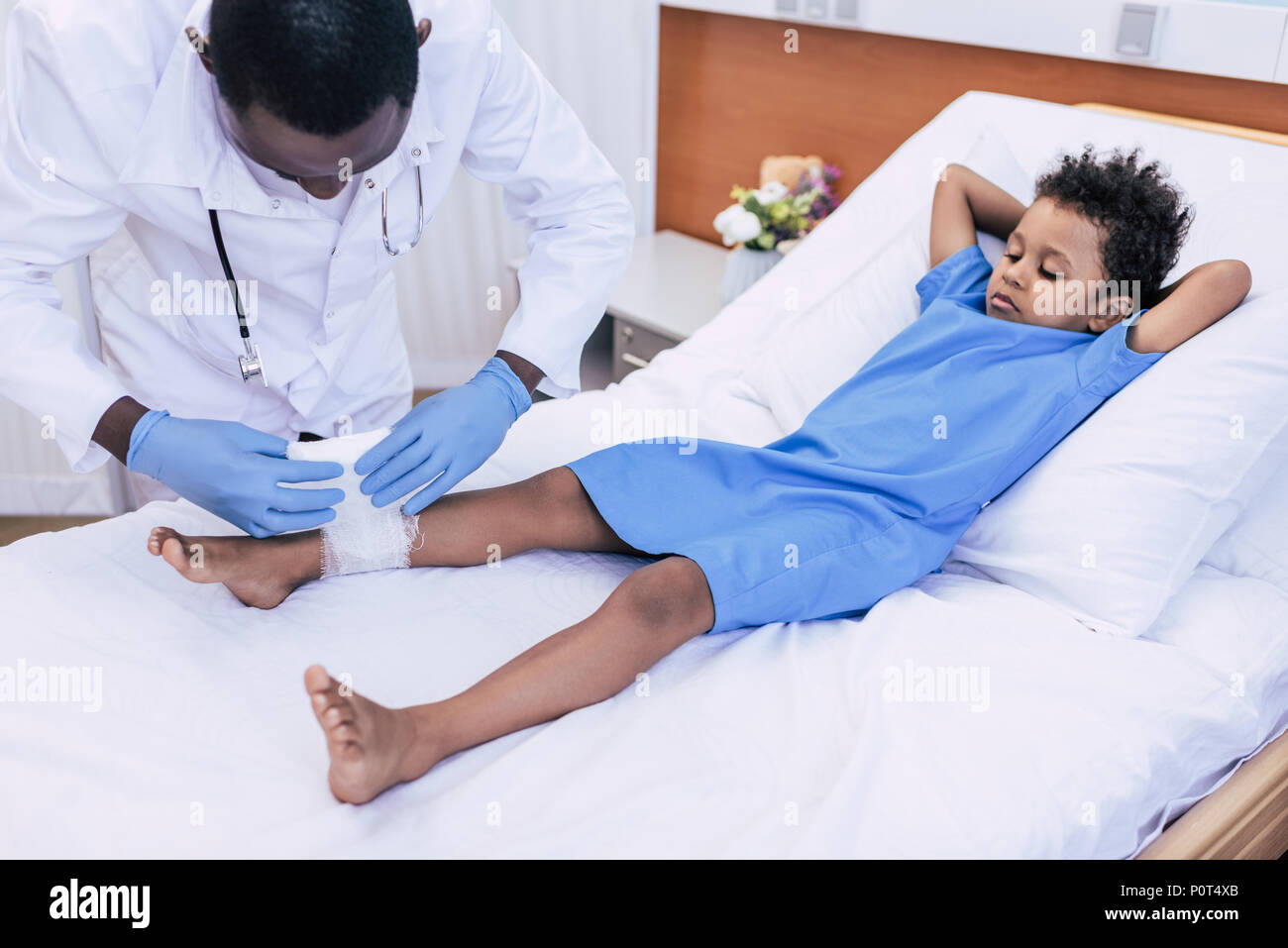african american doctor in medical gloves putting on bandage on ...