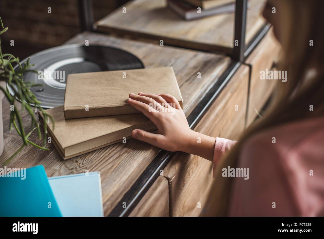 partial view of little girl taking book from bookshelf at home Stock ...