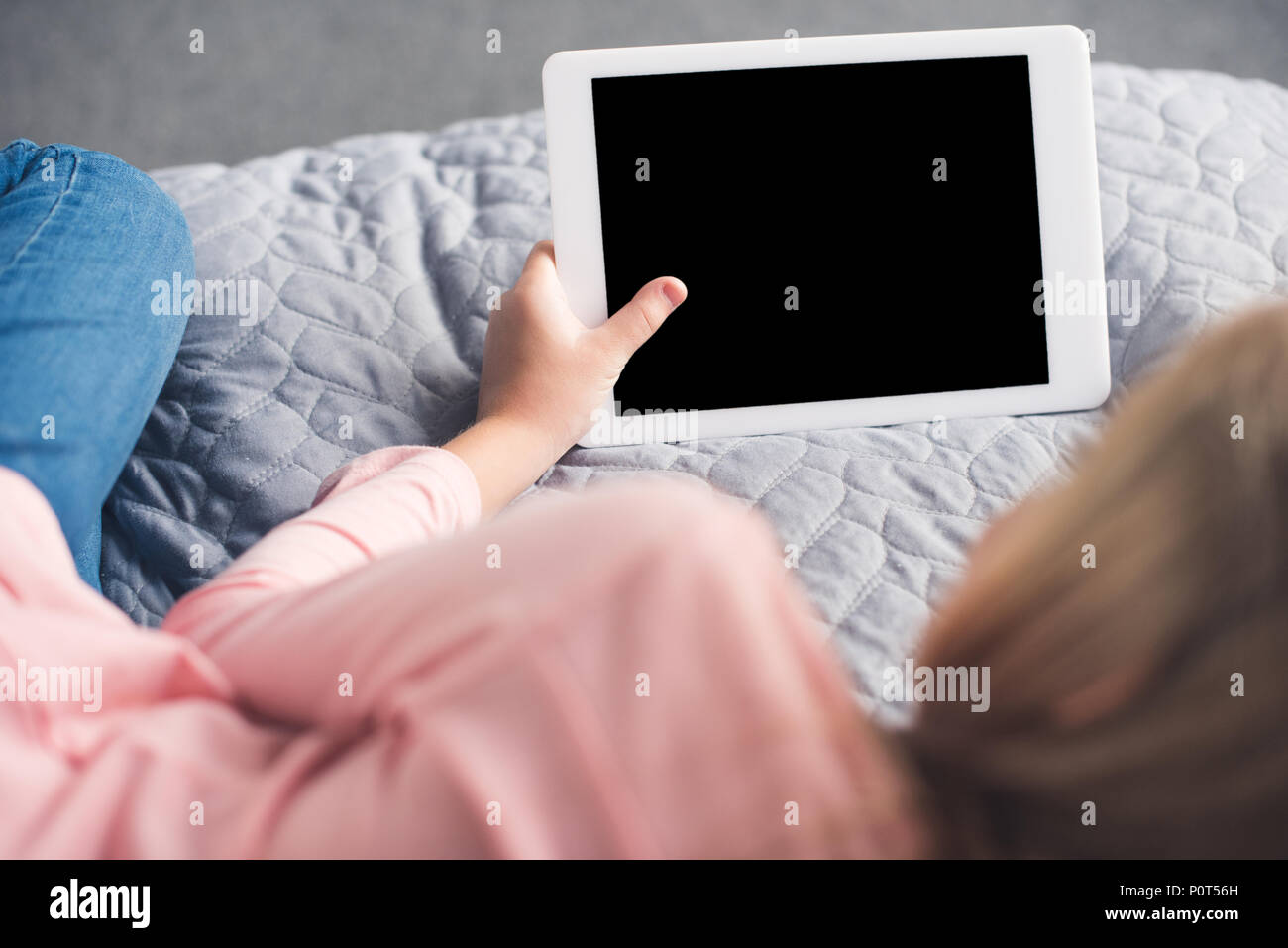 partial view of kid holding tablet with blank screen at home Stock ...
